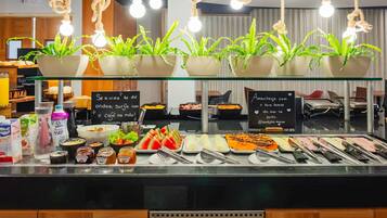Um balcão de buffet com diversos alimentos e acompanhamentos.