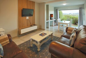 Apartamento família, sacada, vista para o jardim | Área de estar | TV de tela plana 41 polegadas com canais via satélite, lareira