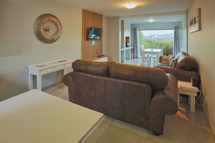 Apartamento família, sacada, vista para o jardim | Área de estar | TV de tela plana 41 polegadas com canais via satélite, lareira