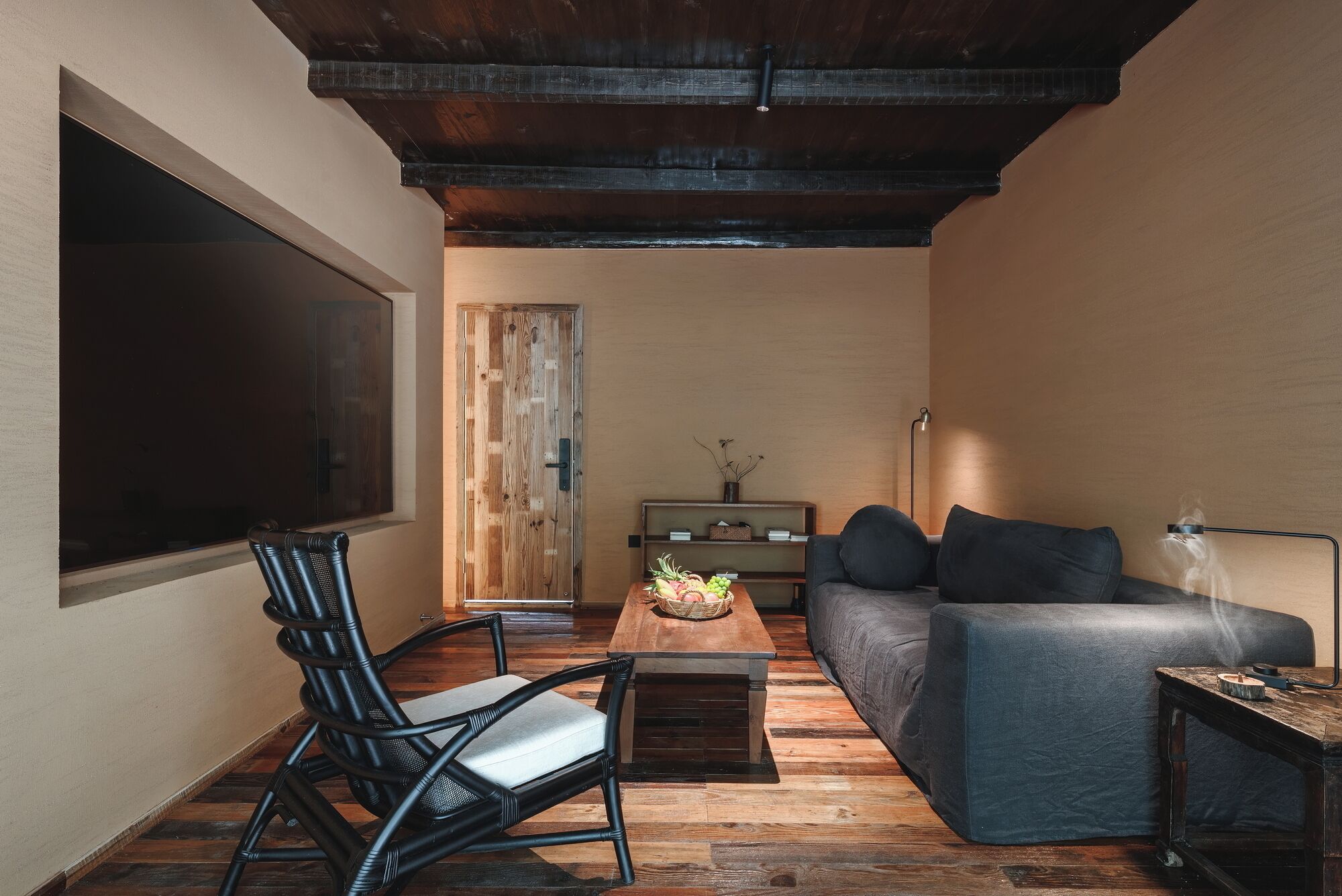 Uma sala de estar aconchegante com um sofá, uma poltrona, uma mesa de centro e uma luminária.
