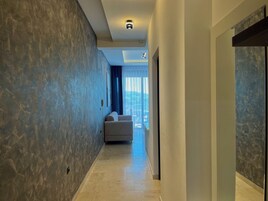 Suíte superluxo, vista parcial para o mar | Área de estar | Smart TV 70 polegadas com canais digitais