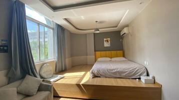 Quarto moderno com uma cama, um sofá e uma janela.