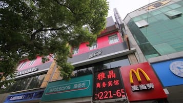 Um edifício comercial com várias lojas, incluindo um McDonald's e uma farmácia Watsons.