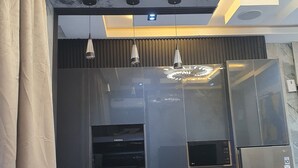 Uma cozinha moderna com eletrodomésticos embutidos, iluminação pendente e bancada de mármore.