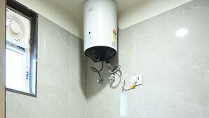 Casa de banho com sanita, bidé, porta-toalhas e esquentador.