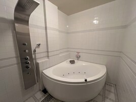 Uma casa de banho moderna com uma banheira independente, um chuveiro e um aviso de proibição de fumar.