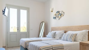 Quarto com duas camas, cabeceira de madeira, espelho e um objeto decorativo na parede.