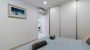 Quarto com cama, um quadro na parede e um guarda-roupa.