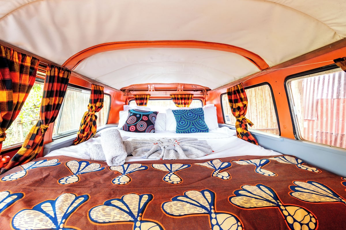 Um interior aconchegante com uma cama, cortinas e uma janela.