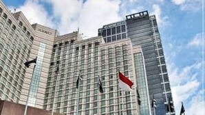 Um edifício de vários andares com uma placa de destaque que diz "PLAZA INDONÉSIA".