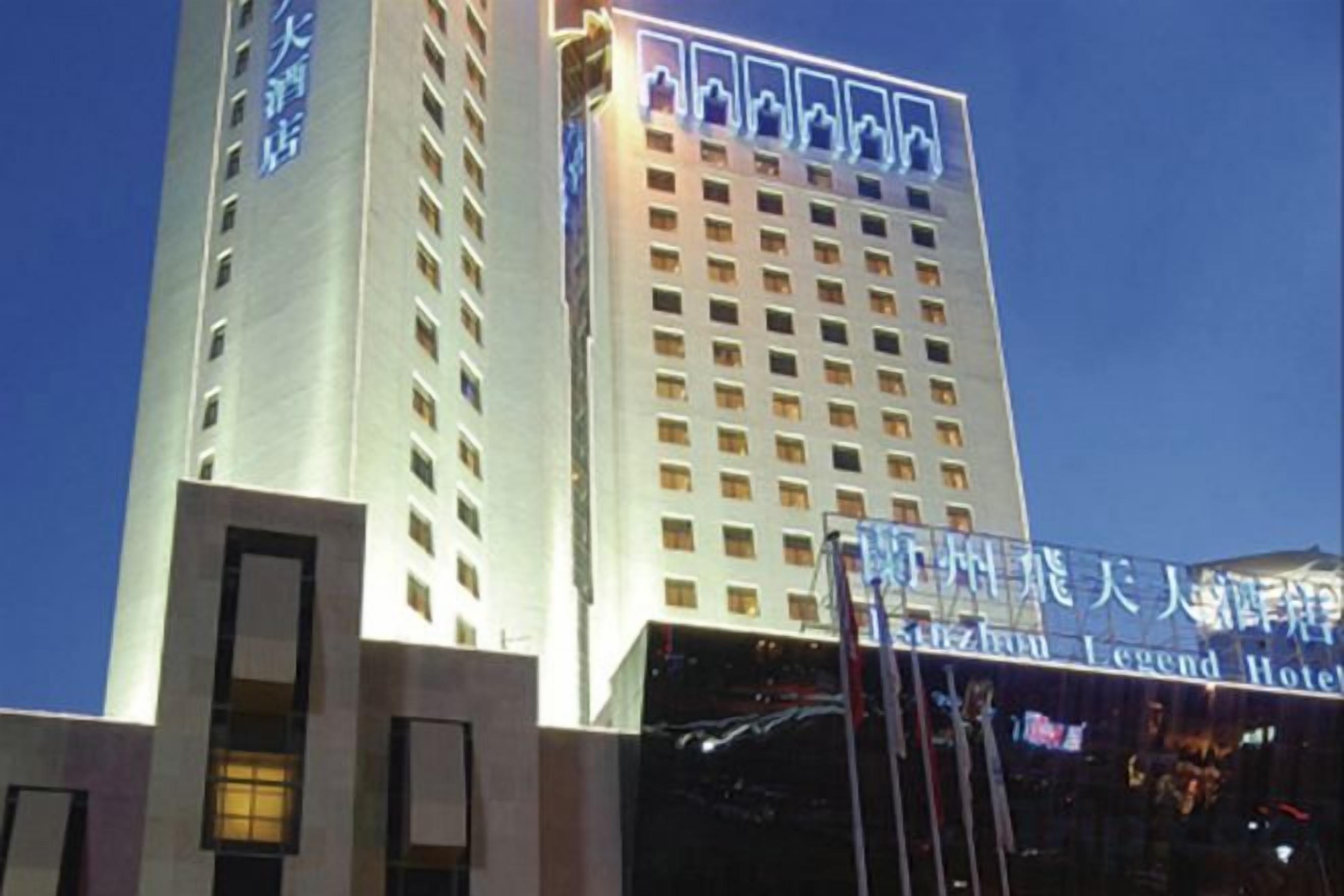 Um hotel imponente com vários andares e uma placa chamativa do 'Legend Hotel'.
