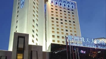 Um hotel imponente com vários andares e uma placa chamativa do 'Legend Hotel'.