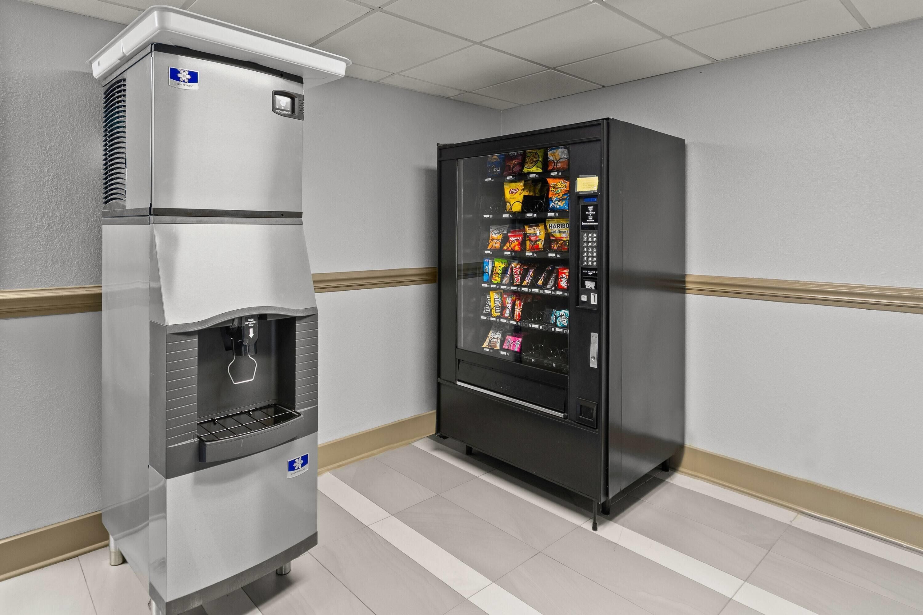 Máquina de vendas com dispensador de água e opções de lanches.