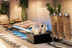 Disposição de buffet com diversos alimentos e bebidas.