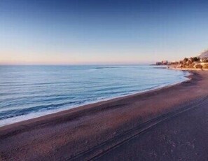 Uma praia com céu limpo e mar calmo.