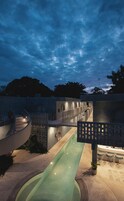 Uma estrutura arquitetônica moderna com piscina, escadas e área de bar.