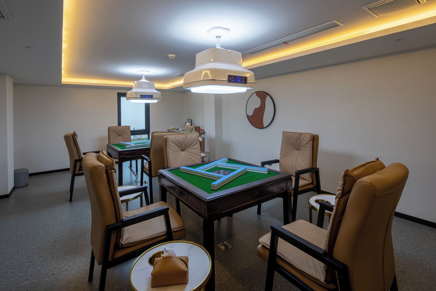 Uma sala de conferências com mesa de bilhar, poltronas de couro e iluminação no teto.