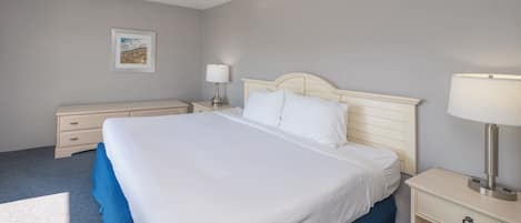 Quarto bem arrumado com cama, mesas de cabeceira e um quadro na parede.