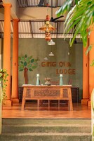 Uma mesa de madeira com uma peça central decorativa, uma parede com um mural de árvore e o texto 