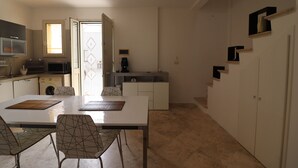 Uma cozinha compacta com área de refeições, máquina de lavar e micro-ondas.