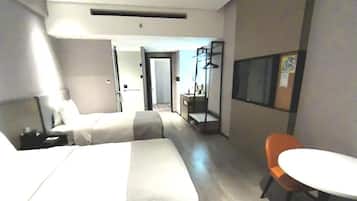 Quarto de hotel moderno com uma cama grande, uma mesa de trabalho, uma cadeira e uma pequena mesa.