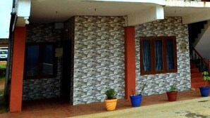 Um edifício com fachada de pedra, escadaria e plantas em vasos.