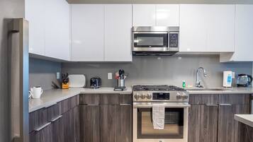 Apartamento Deluxe, cozinha | Cozinha privada | Um frigorífico/congelador grande, um micro-ondas, um forno