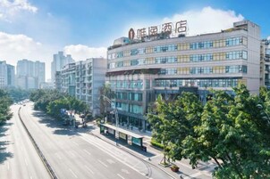 Um hotel com vários andares e design moderno, com uma sinalização chamativa no topo.