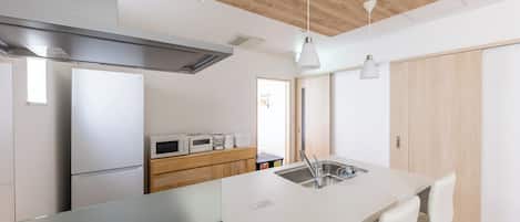 Um frigorífico/congelador grande, um micro-ondas, uma placa de cozinha