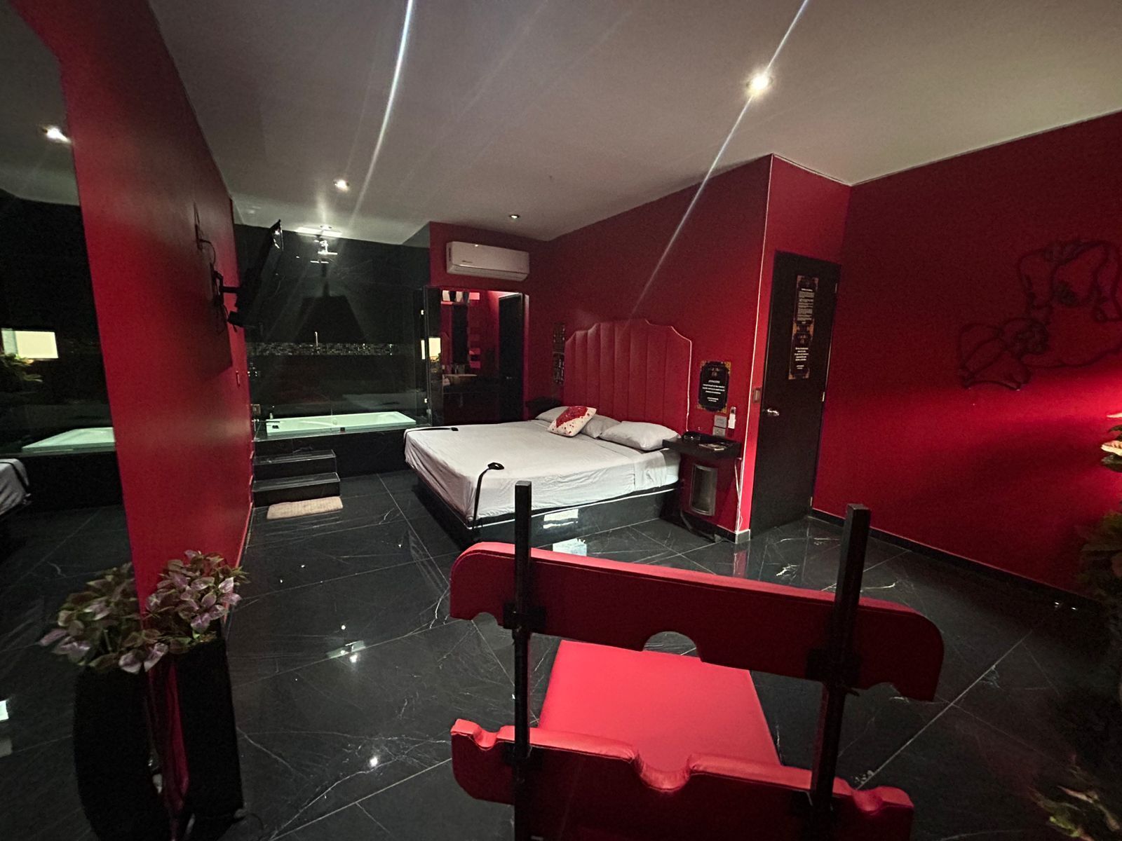 Quarto de hotel moderno com uma cama grande, uma mesa de escritório e uma área de estar.