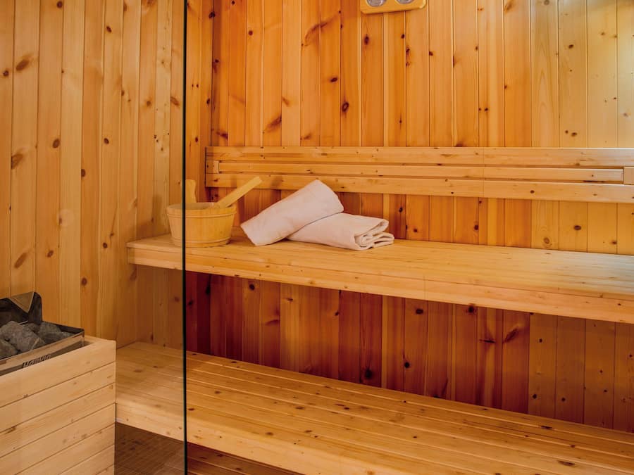 Uma sauna de madeira com bancos e um banco com toalhas.