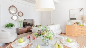 Uma sala de estar moderna com canto de jantar preparado para refeição.
