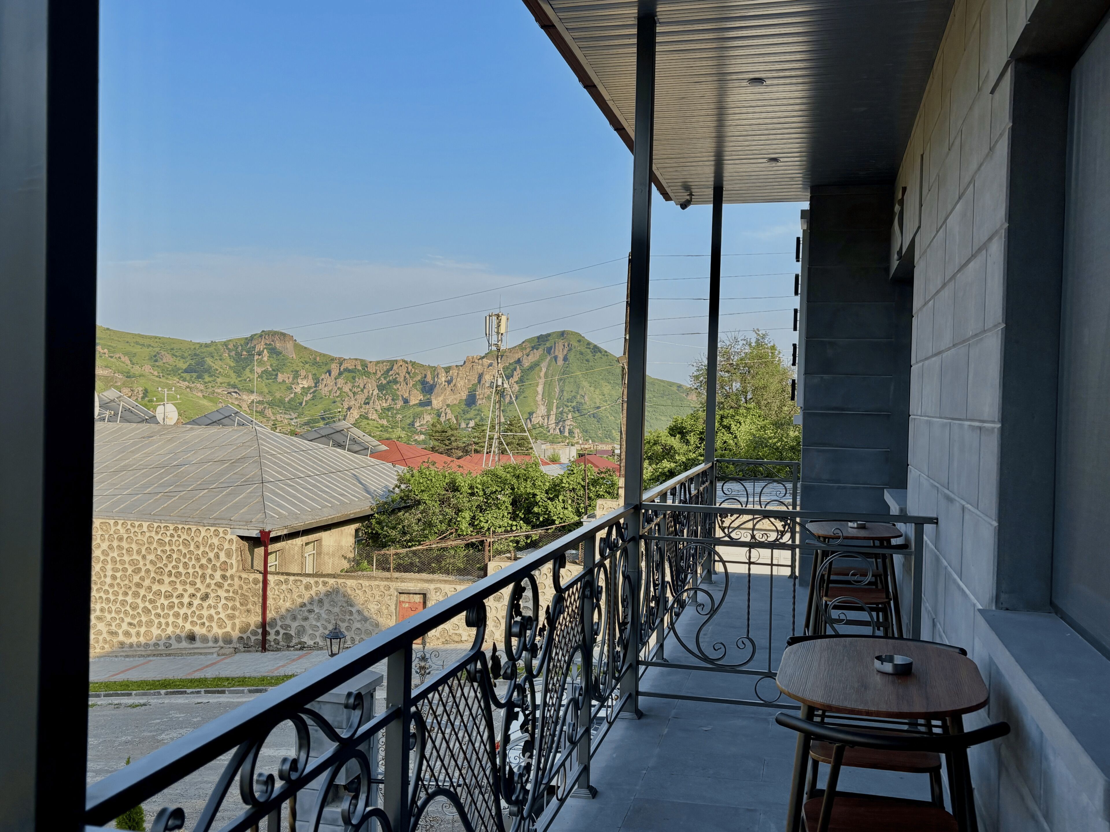 Uma varanda com vista para uma montanha, uma mesa e uma cadeira.