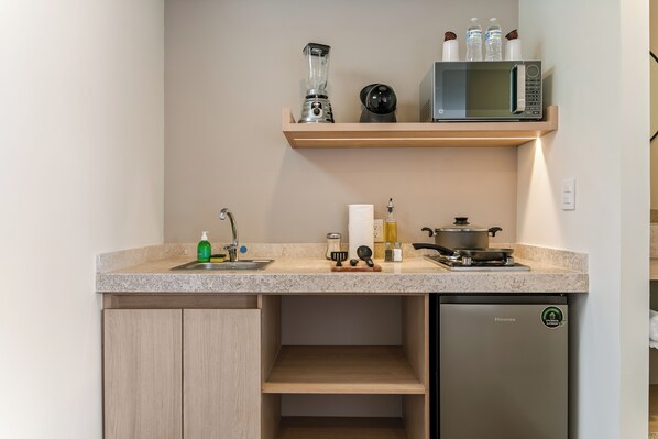 Cozinha compacta com pia, bancada, micro-ondas e máquina de lavar louça.