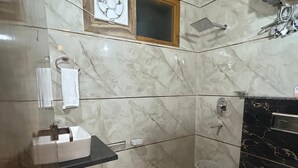Casa de banho com lavatório, sanita e área de duche.