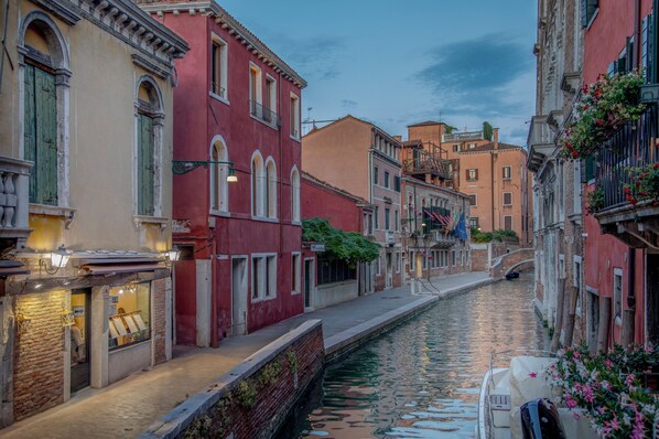 Um canal estreito em uma cidade histórica europeia, com edifícios em ambas as margens.
