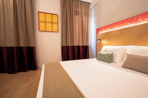Quarto de hotel com uma cama grande, cabeceira de madeira e cortinas.
