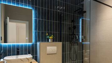 Quarto Duplo Deluxe, vista parcial para o mar | Casa de banho | Um polibã, um secador de cabelo, chinelos, toalhas fornecidas