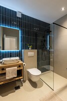 Quarto Duplo Deluxe, vista parcial para o mar | Casa de banho | Um polibã, um secador de cabelo, chinelos, toalhas fornecidas 