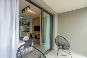 Um apartamento moderno com área de jantar, cozinha e sala de estar com televisão.
