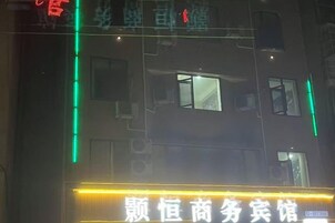 Fachada de edifício com letreiros iluminados e janelas.
