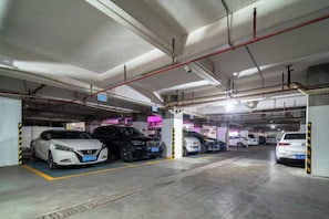 Garagem subterrânea em vários níveis, com vários carros estacionados.