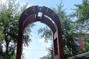 Um grande arco com texto, rodeado por árvores e edifícios.