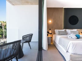 A modern hotel room with a bed, a small table, and a chair.