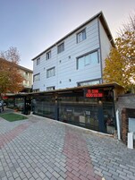 Um edifício moderno com fachada de vidro e um painel digital exibindo preços.