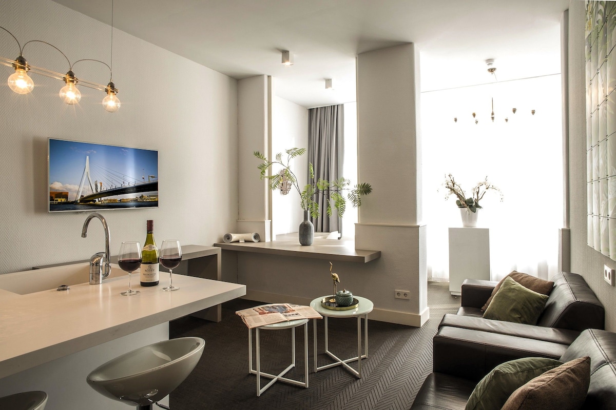 Uma sala de estar moderna com um sofá, uma mesa de centro e uma área de jantar com um balcão.