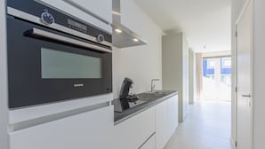 Uma cozinha moderna com forno embutido e máquina de café.