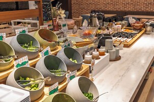 Buffet com diversos alimentos e utensílios.
