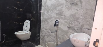 Casa de banho com sanita, bidé e lavatório.