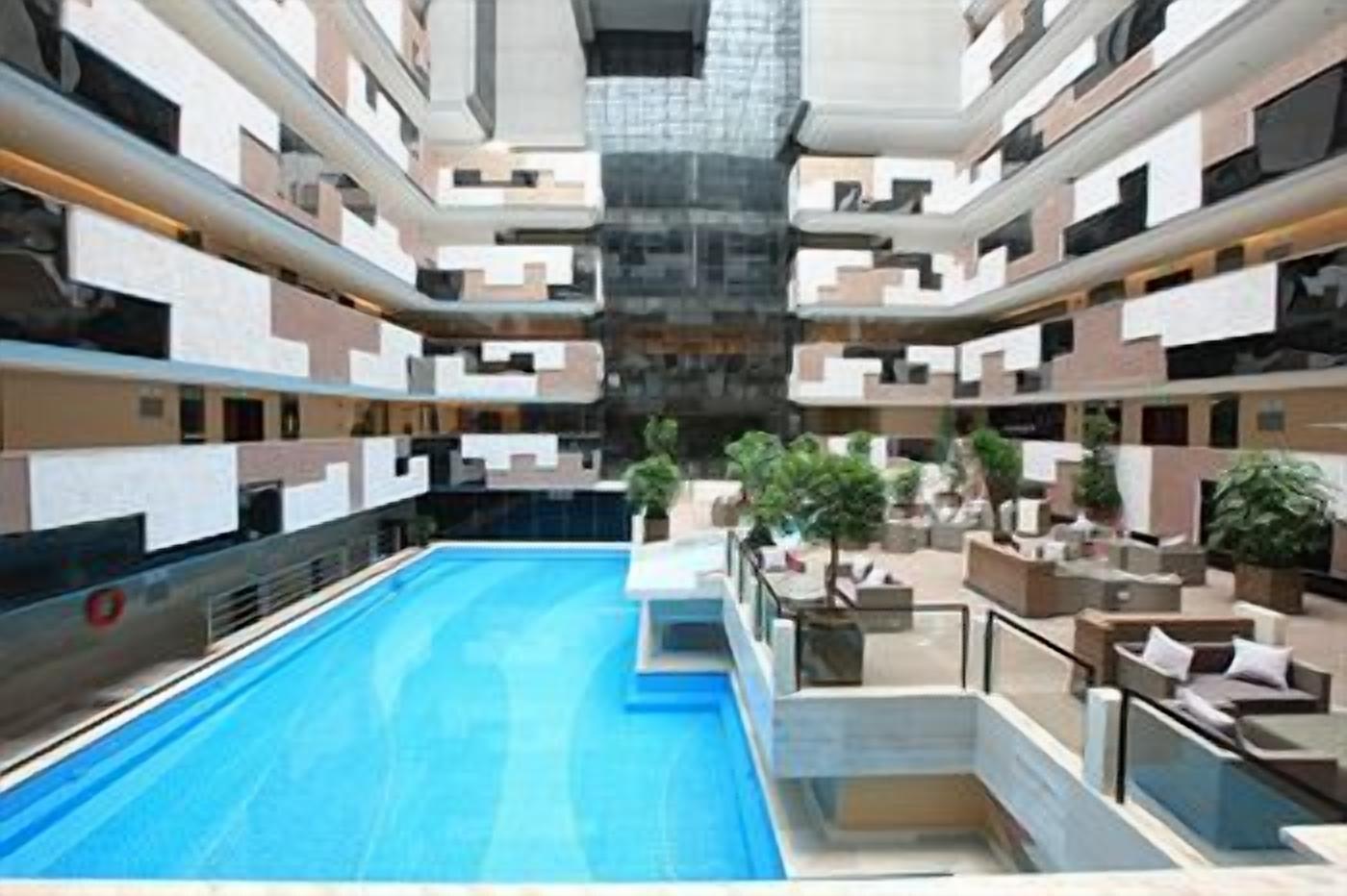 Piscina interna com vários níveis de varandas e áreas de estar.